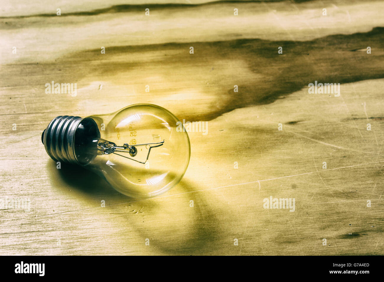 Photograph of a retro light bulb on a wood table Stock Photo - Alamy