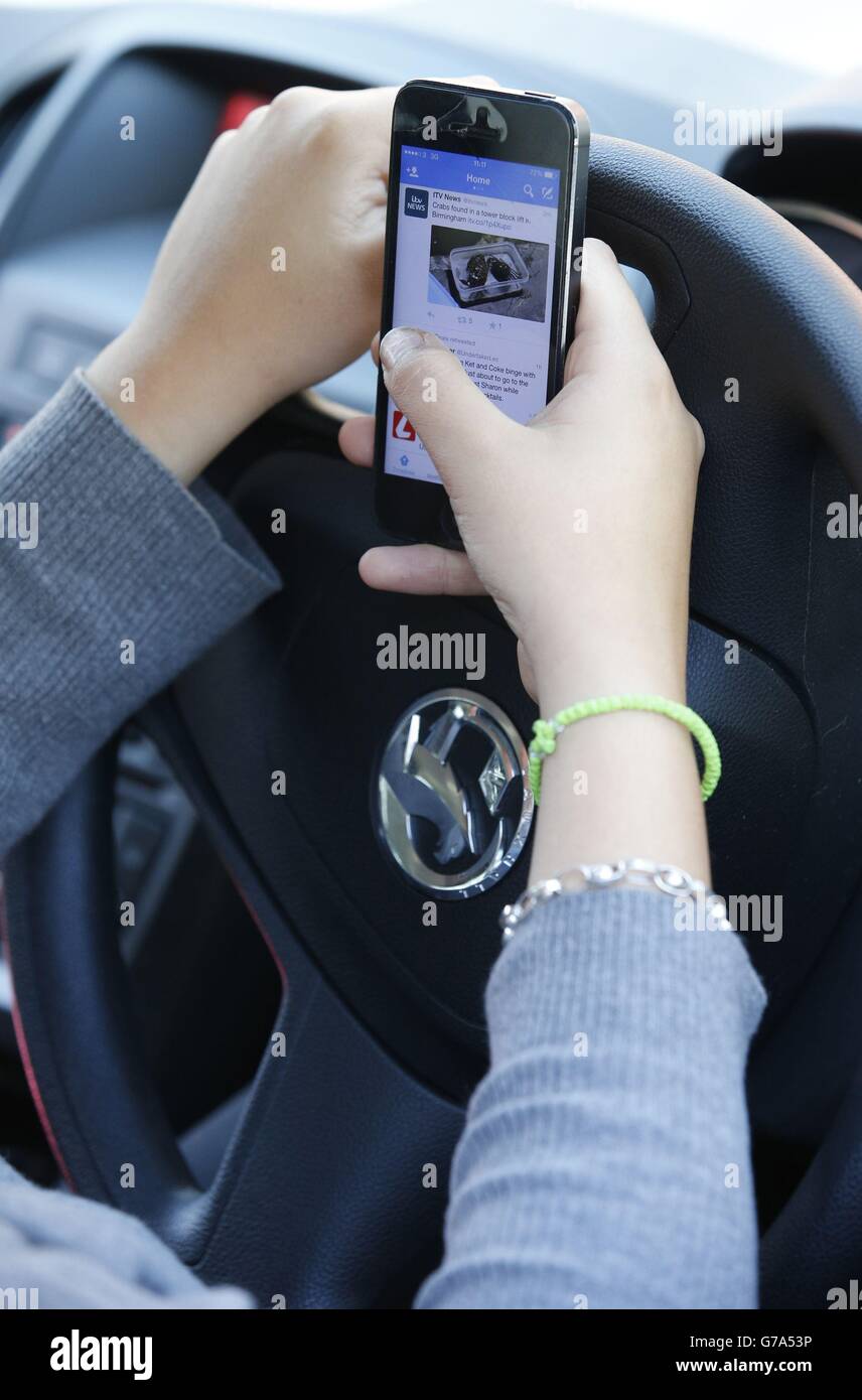 PICTURE POSED BY MODEL A woman texting on her phone whilst driving ...