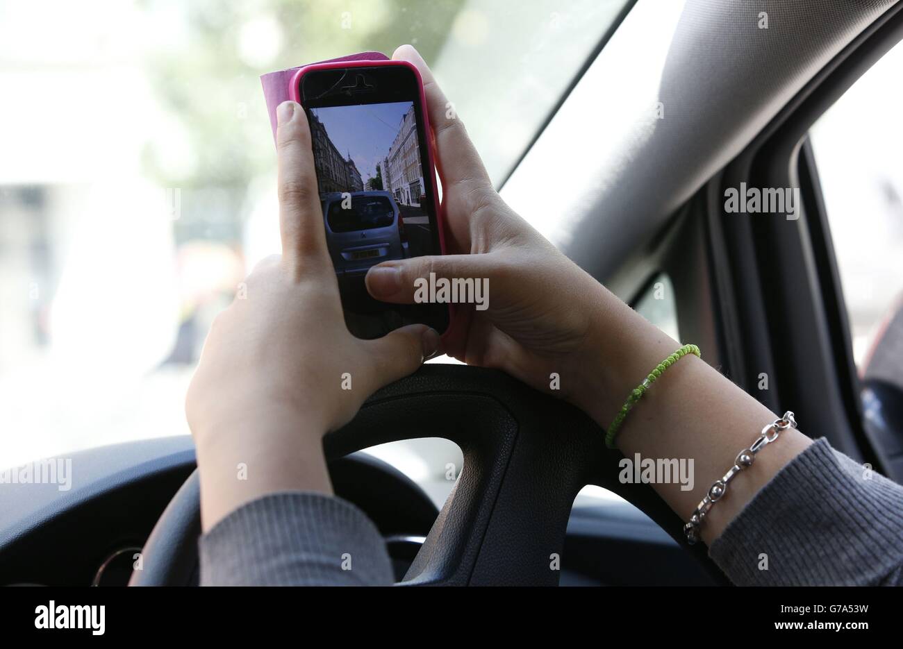 Driving stock. PICTURE POSED BY MODEL A woman takes a photo on her ...