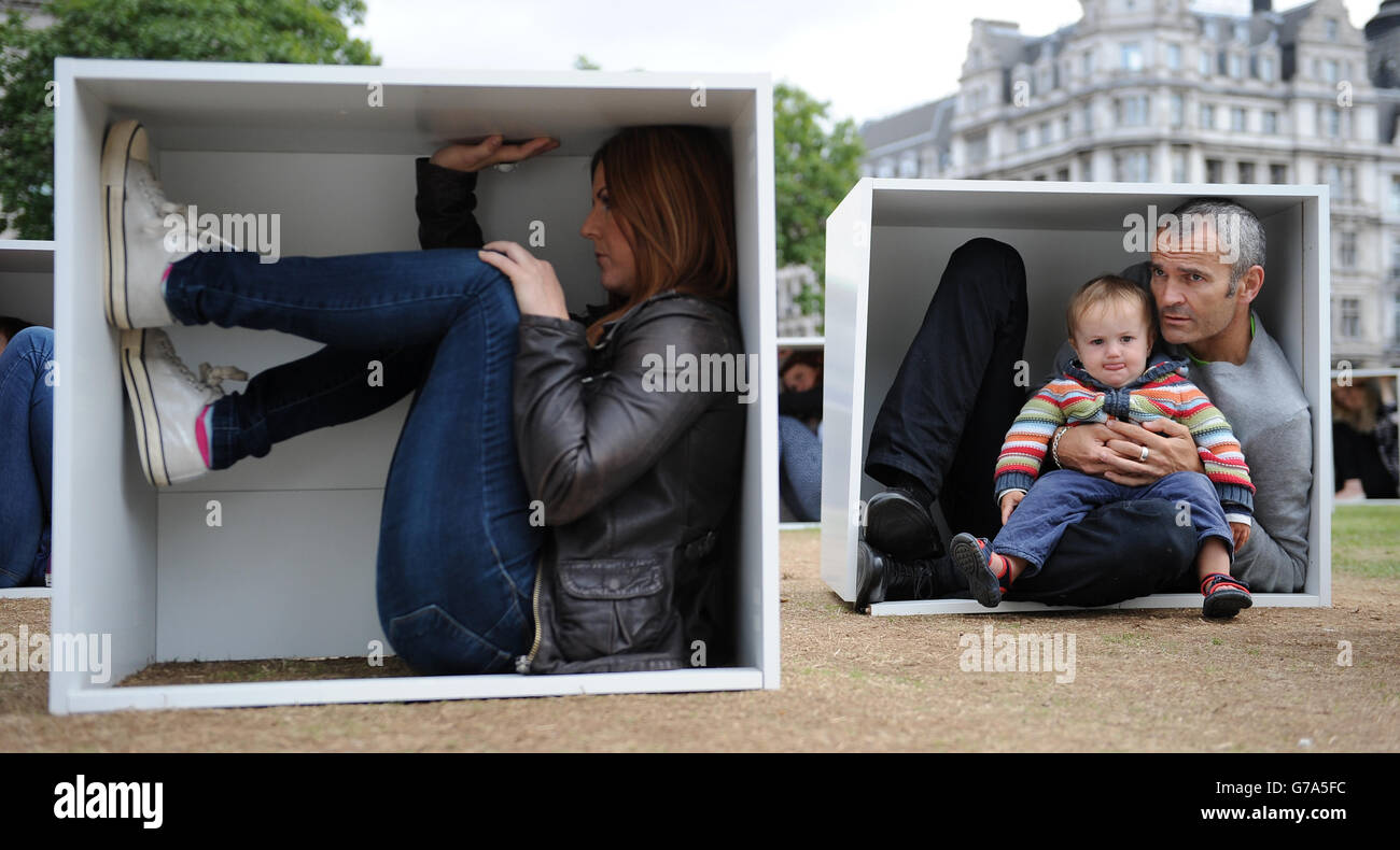 Men, women and children are squashed inside boxes to illustrate the ...