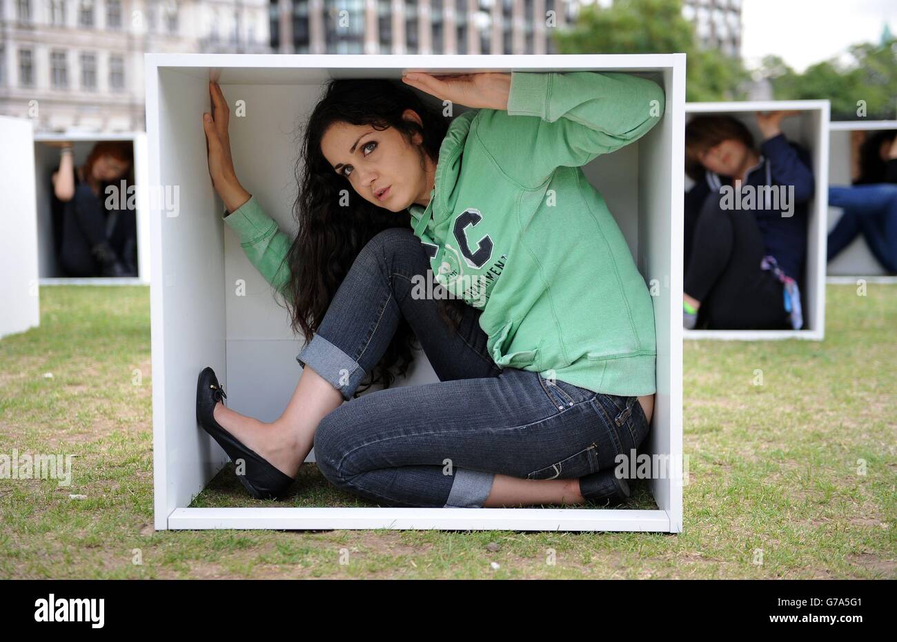 Men, women and children are squashed inside boxes to illustrate the ...