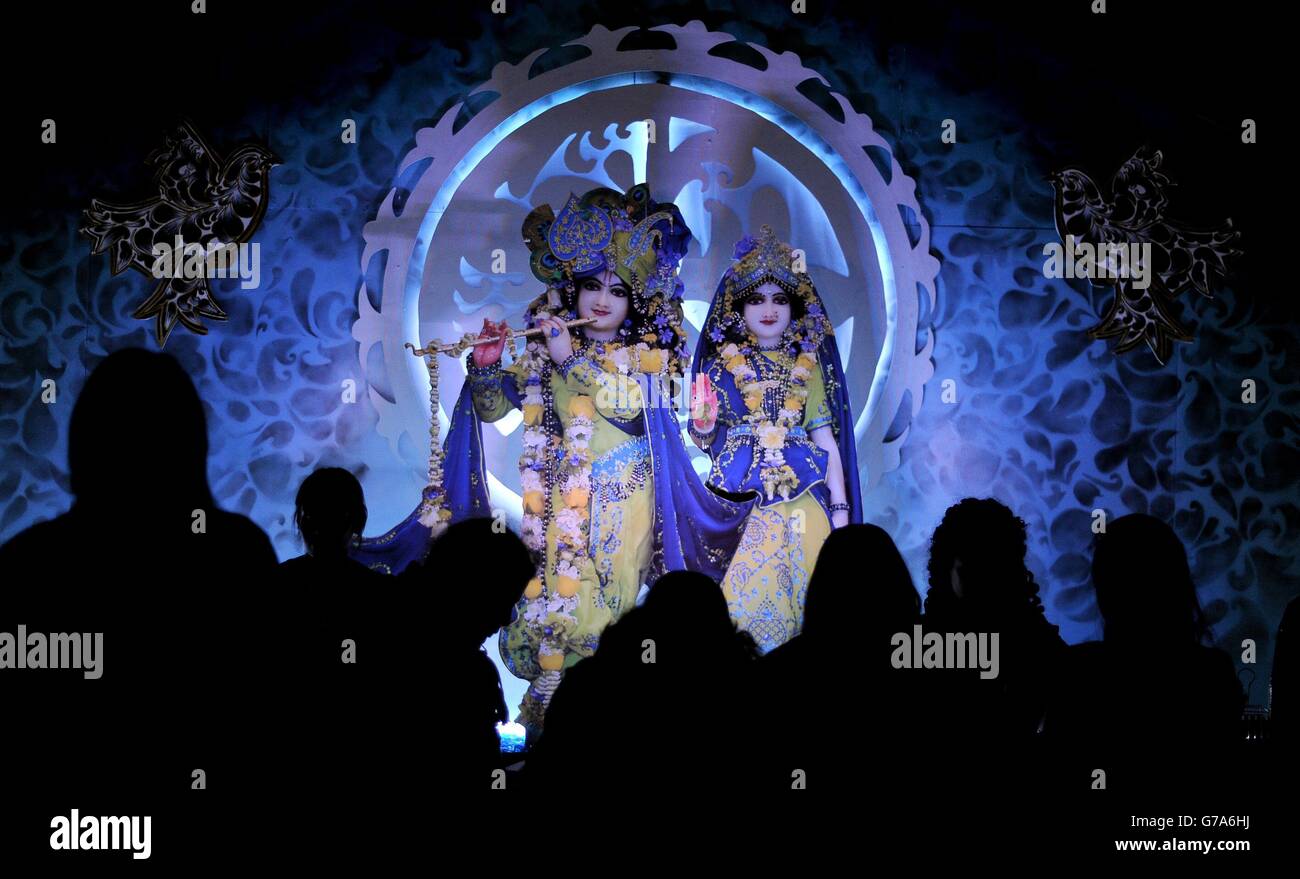 Hare Krishna devotees look up at an image of Lord Krishna and his ...