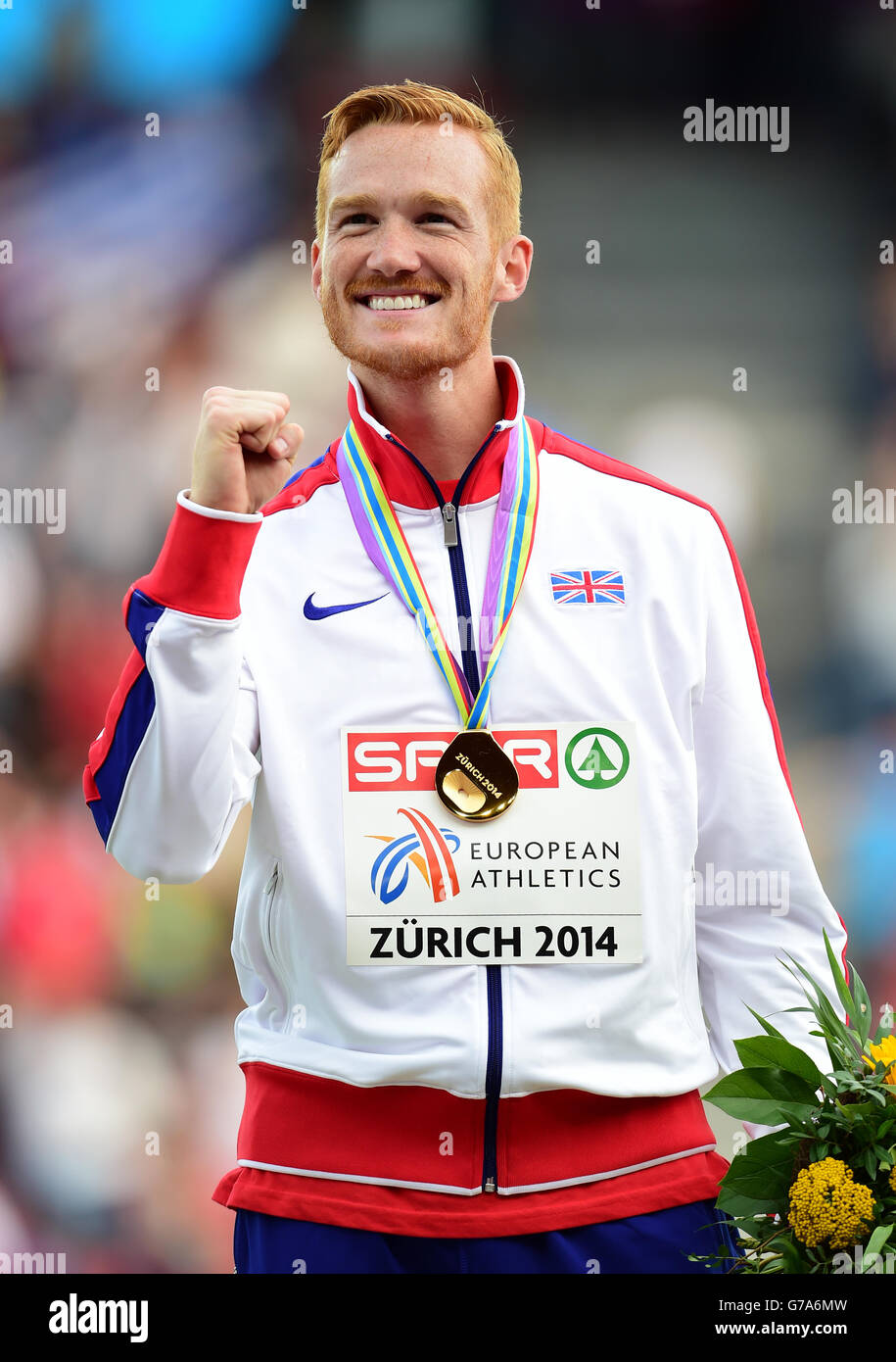 Great Britain's Greg Rutherford stands on the podium with his gold ...