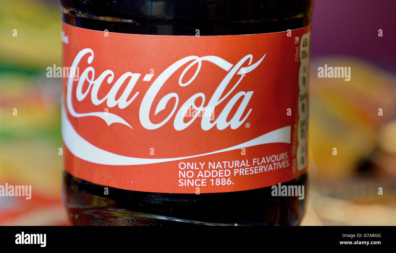 A bottle of Coca Cola with biscuits, crisps, chocolate bars and ...