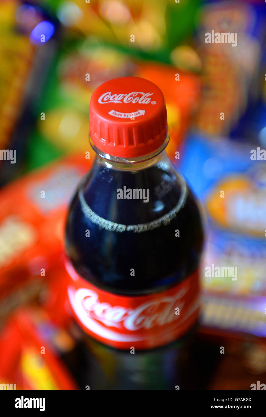 A bottle of Coca Cola with biscuits, crisps, chocolate bars and ...