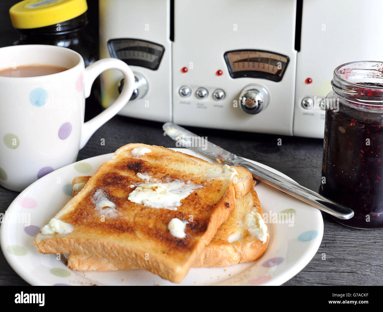 Two slices of buttered white toasted bread on a plate, a cup of tea and ...