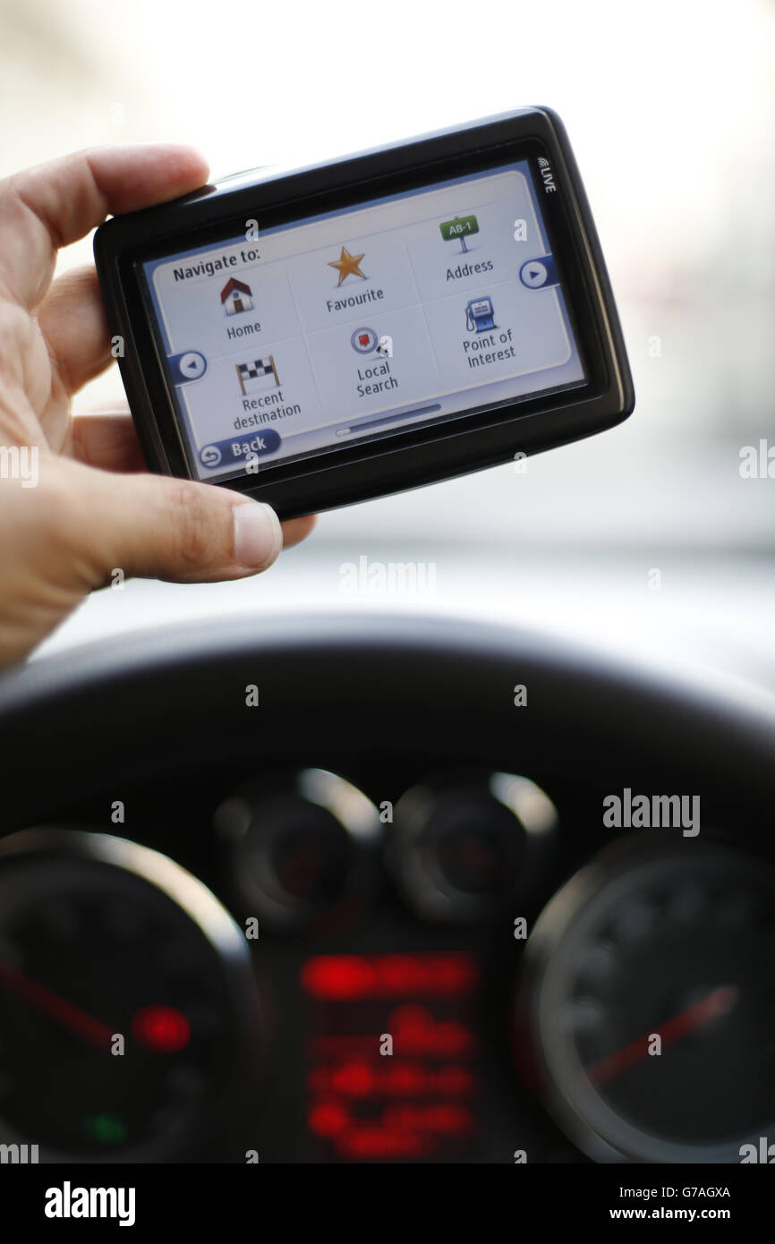 A man uses a satellite Navigator in his car. The sat nav system s a ...