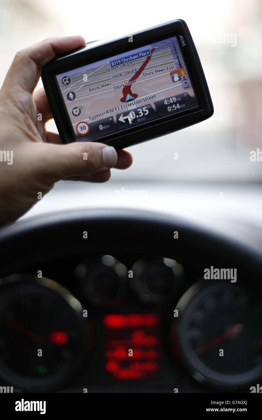 A man uses a satellite Navigator in his car. The sat nav system s a ...