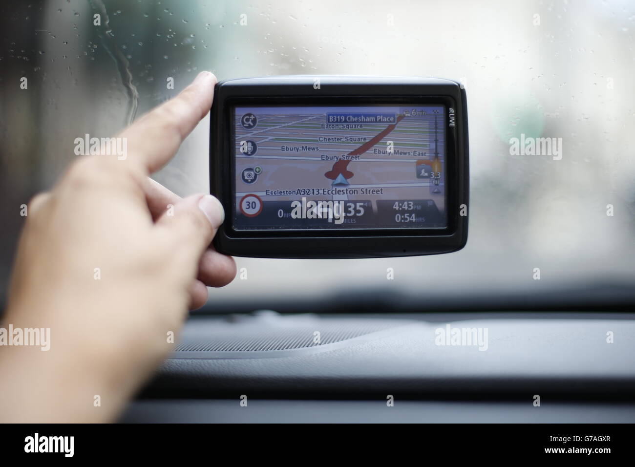 A man uses a satellite Navigator in his car. The sat nav system s a ...