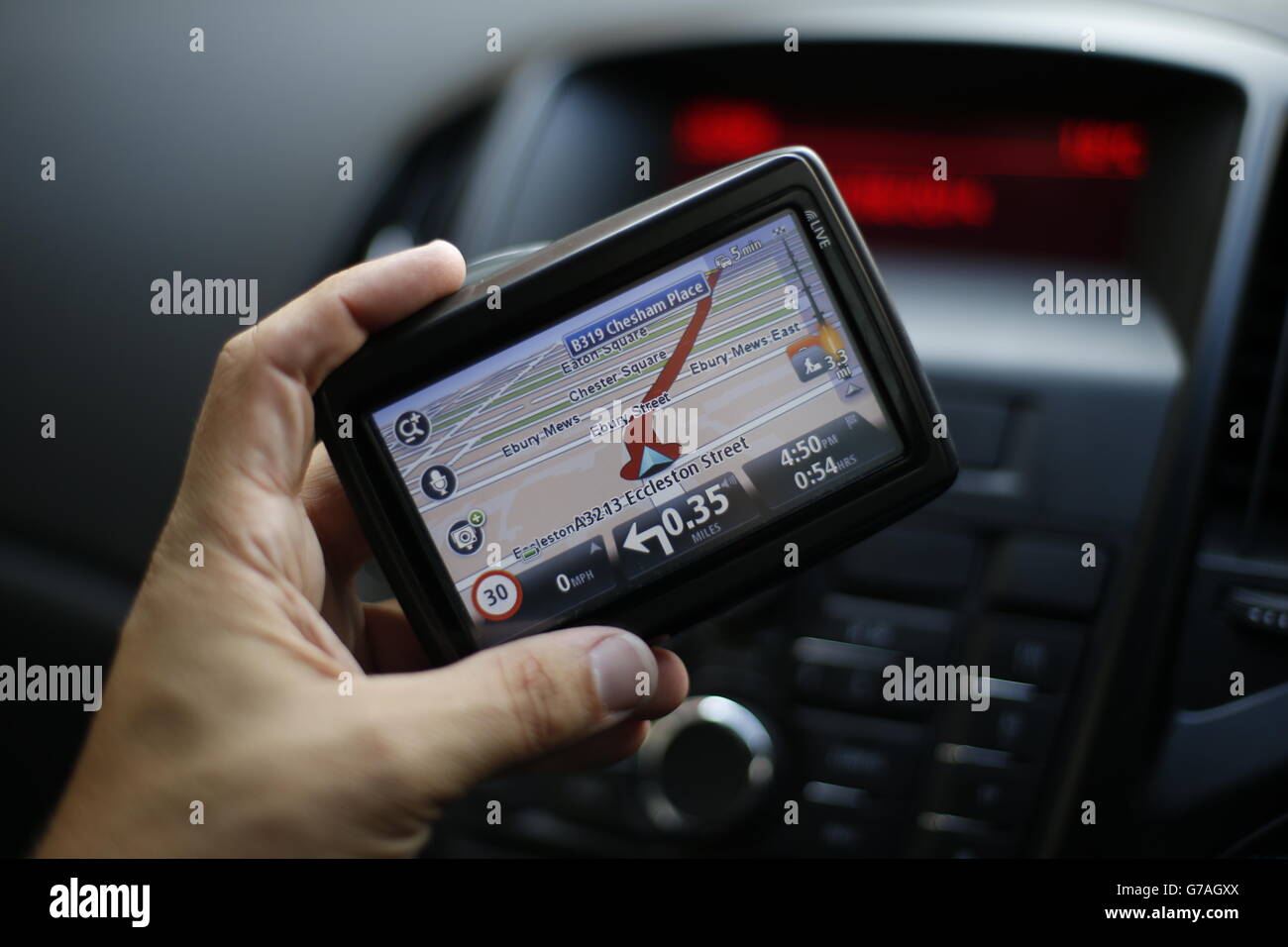 A man uses a satellite Navigator in his car. The sat nav system s a ...