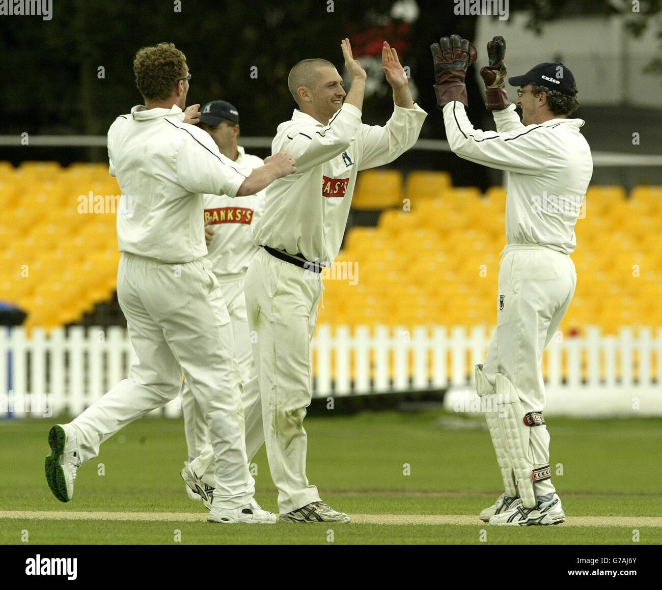 Warwickshire bowler Jim Troughton (centre) celebrates with wicketkeeper ...