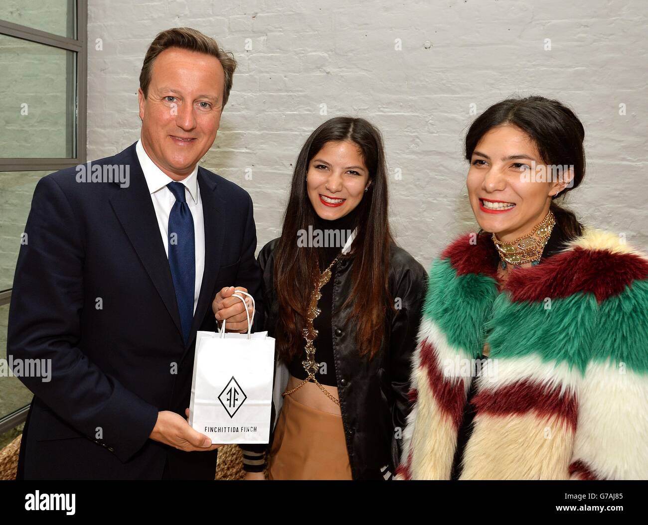 Prime Minister David Cameron holds a gift of hand made jewellery from ...