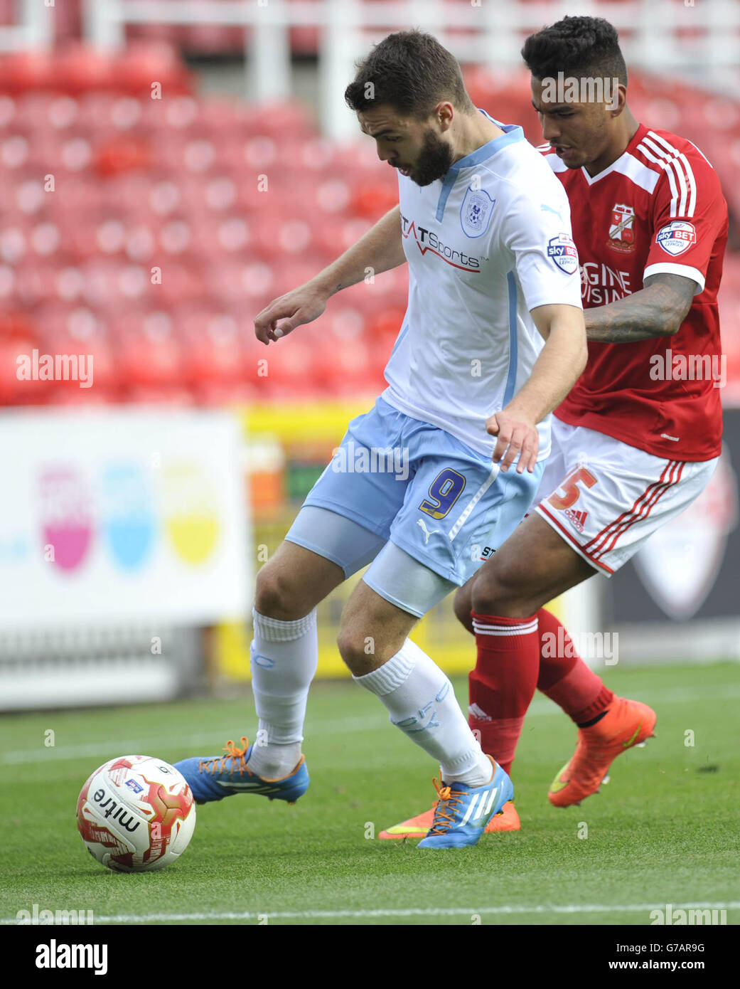 Swindon Town's Joshua Lelan and Coventry City's Josh McQuoid in action ...