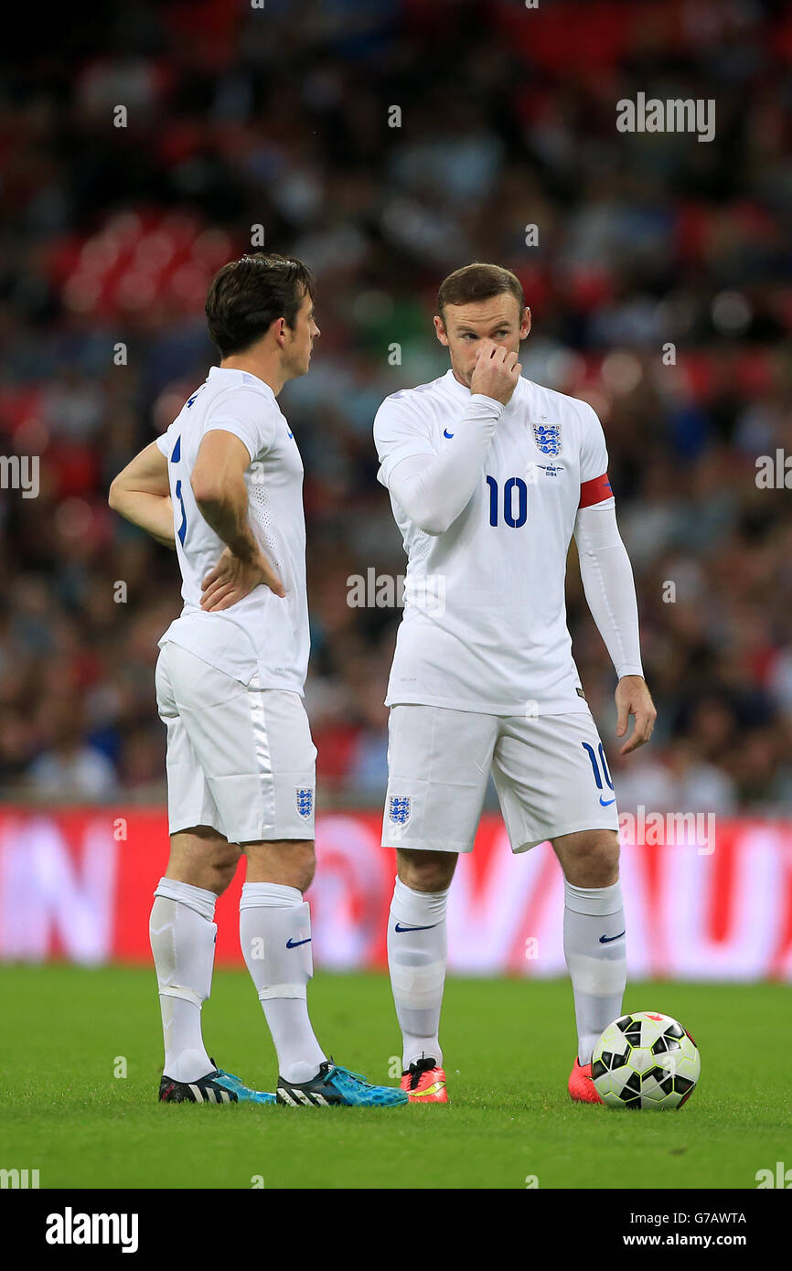 England's Leighton Baines and Wayne Rooney (right) stand over a free ...