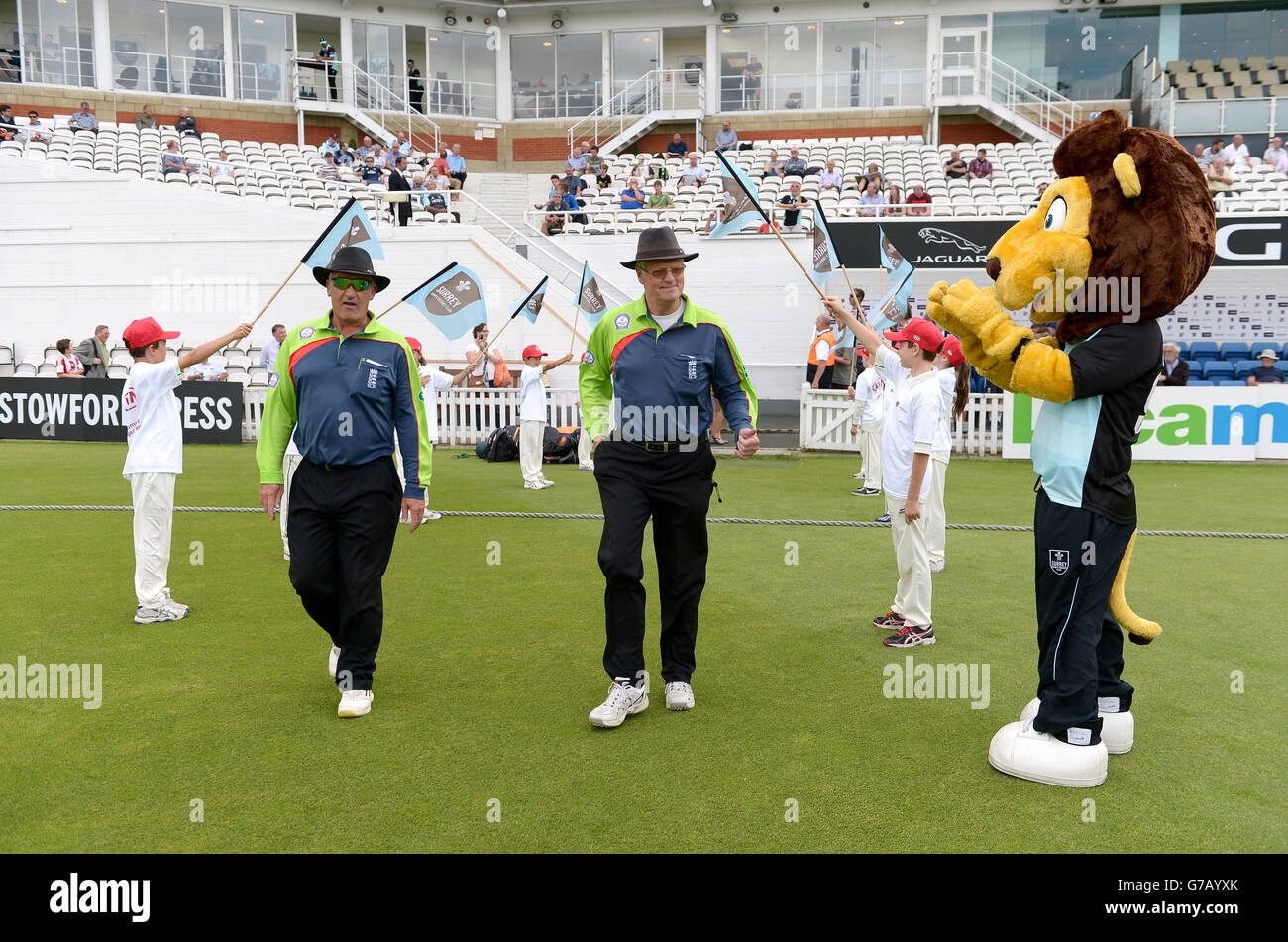 The umpires walk through the guard of honour before the game Stock ...