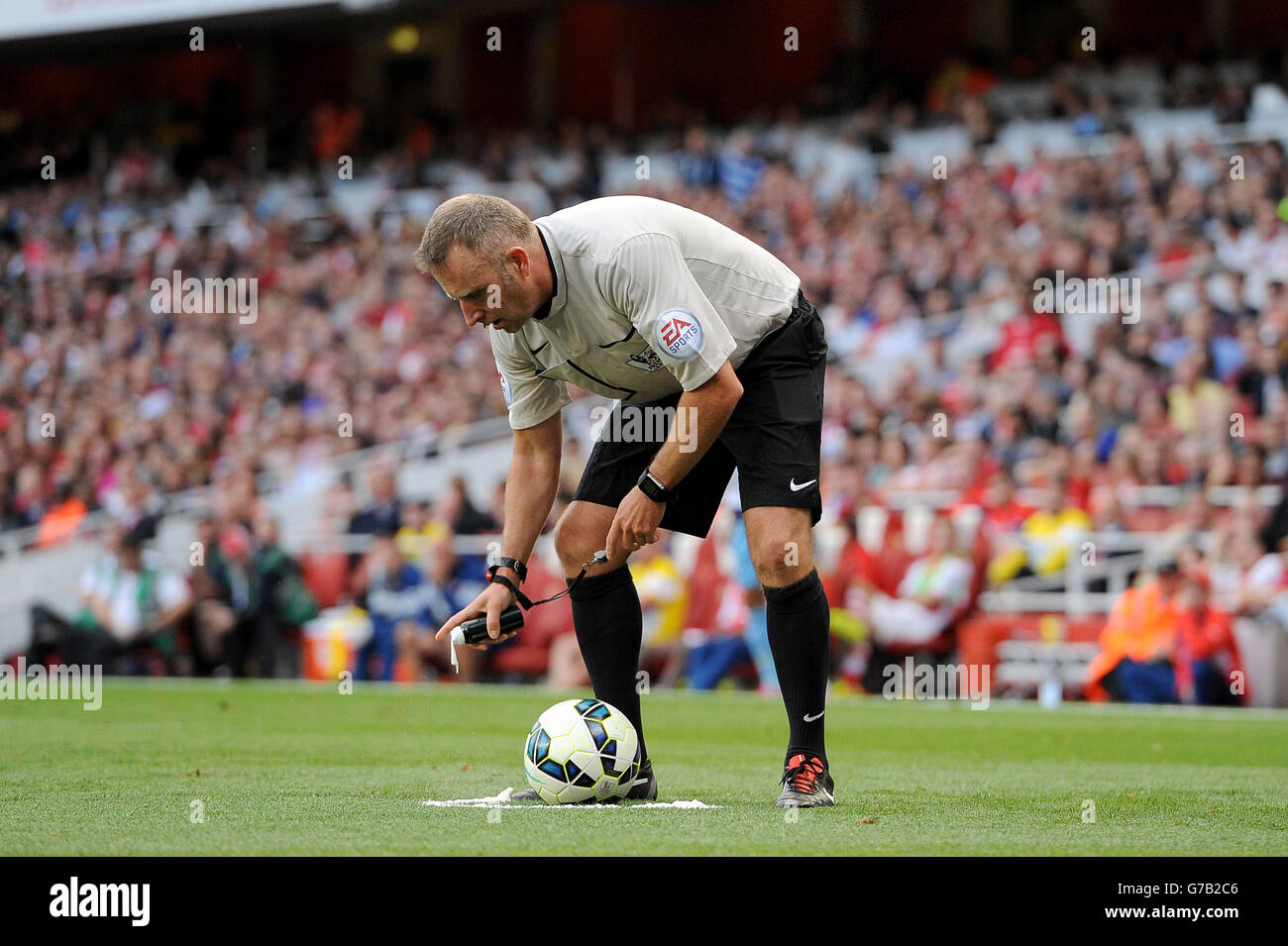 Referee Jonathan Moss uses vanishing spray to mark out the position of ...