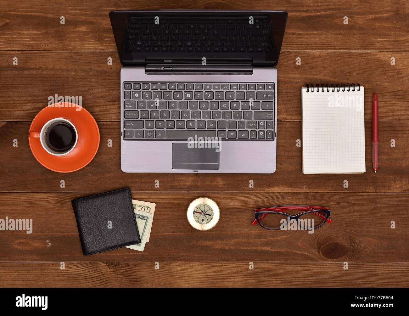 Top view office business desk with laptop,note pad, glasses, on a wood ...