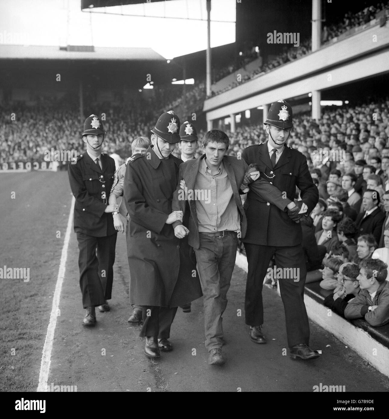 Rioters are escorted out of the ground before the match hi-res stock ...