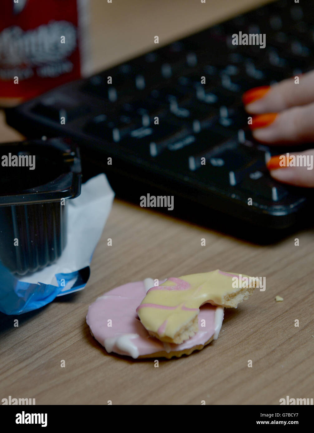 An office workers eats Party Rings biscuits at their desk, London Stock ...