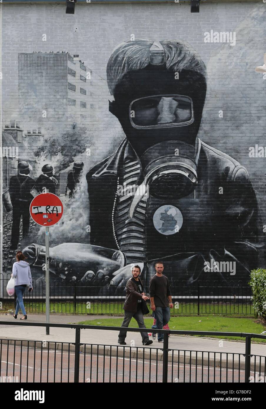 Men walk past a murals in the Bog Side area of Derry on the 20th ...