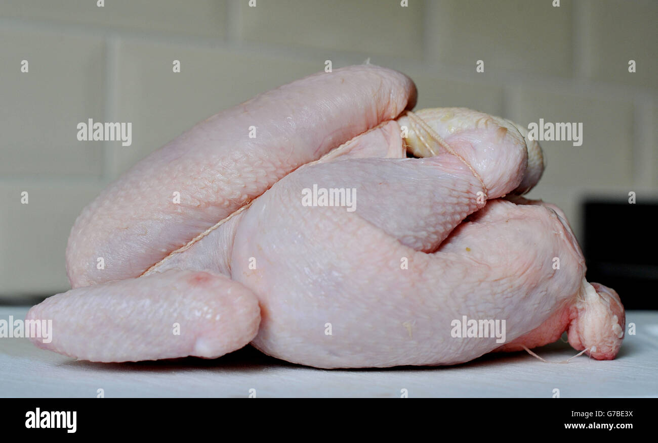 A raw chicken on a chopping board, as poor food hygiene, preparation ...