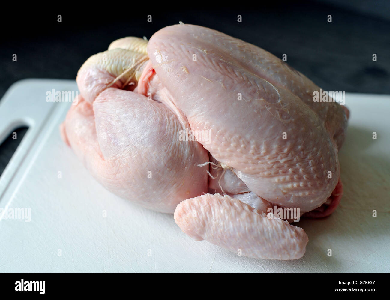 A raw chicken on a chopping board, as poor food hygiene, preparation ...
