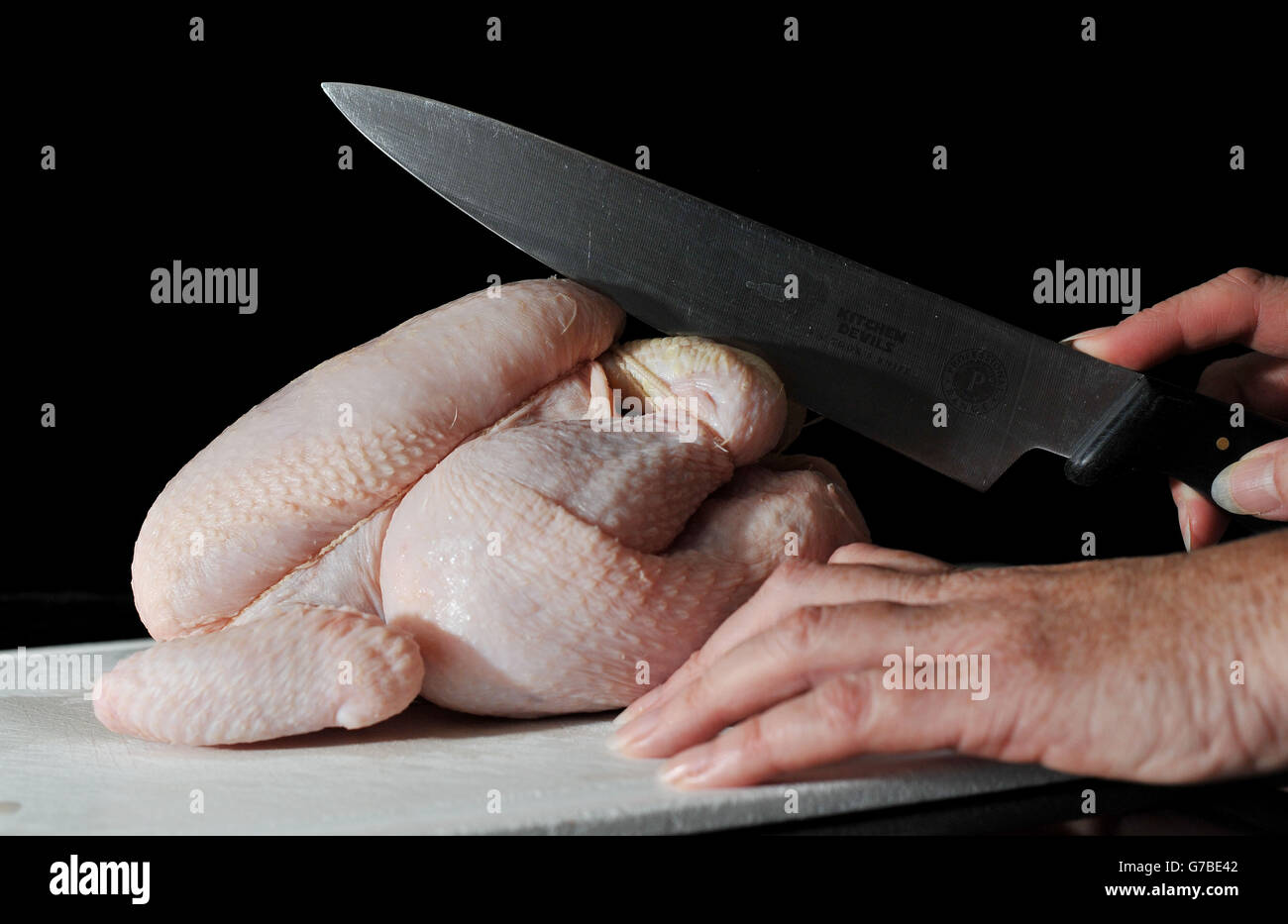 A raw chicken being handled, as poor food hygiene, preparation and ...