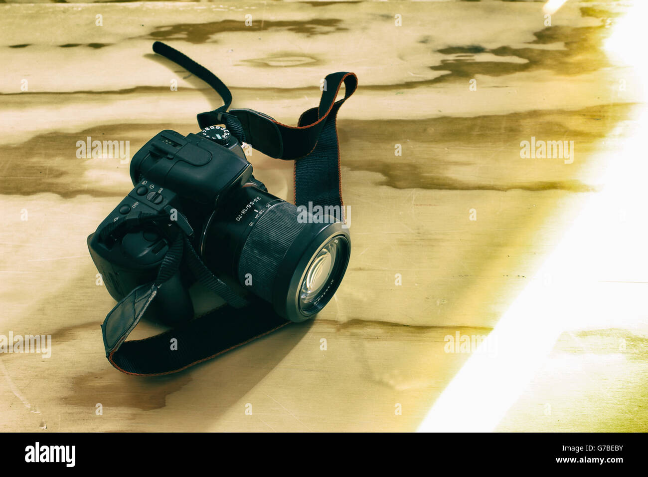 Photograph of a black reflex camera on a wood table Stock Photo - Alamy