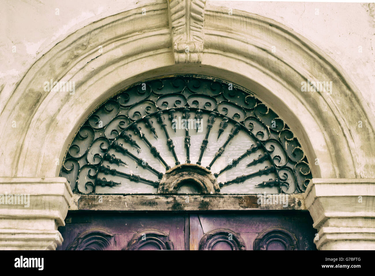 Photograph of an old window with iron abstract figures and a purple ...