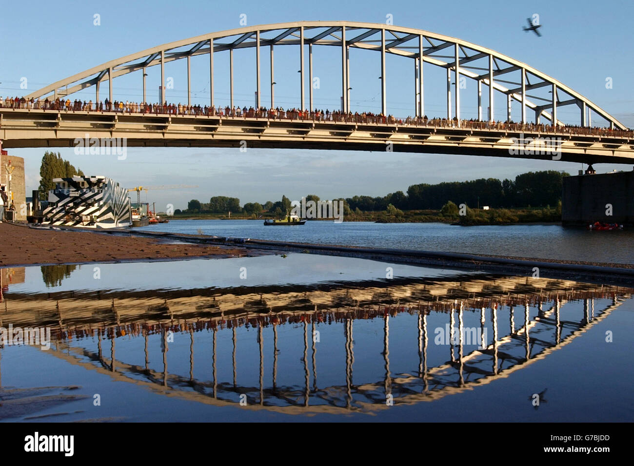 Crowds watch from John Frost Bridge in Arnhem as an aircraft flies past ...