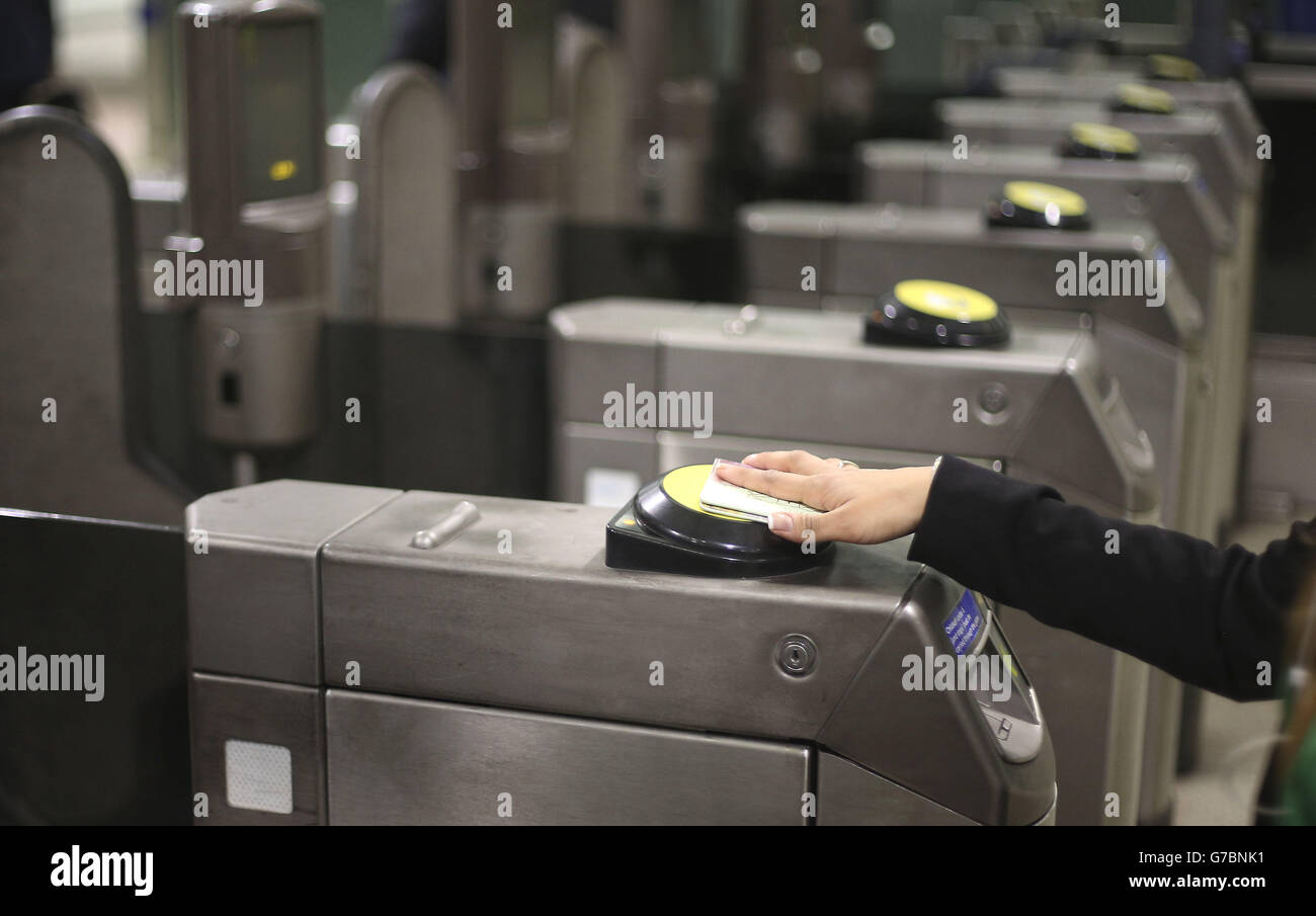 Customers using Oyster cards at the ticket barrier at Canary Wharf ...