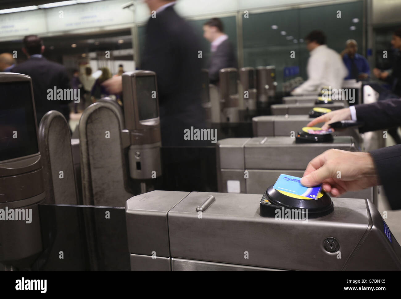 Customers using Oyster cards at the ticket barrier at Canary Wharf ...
