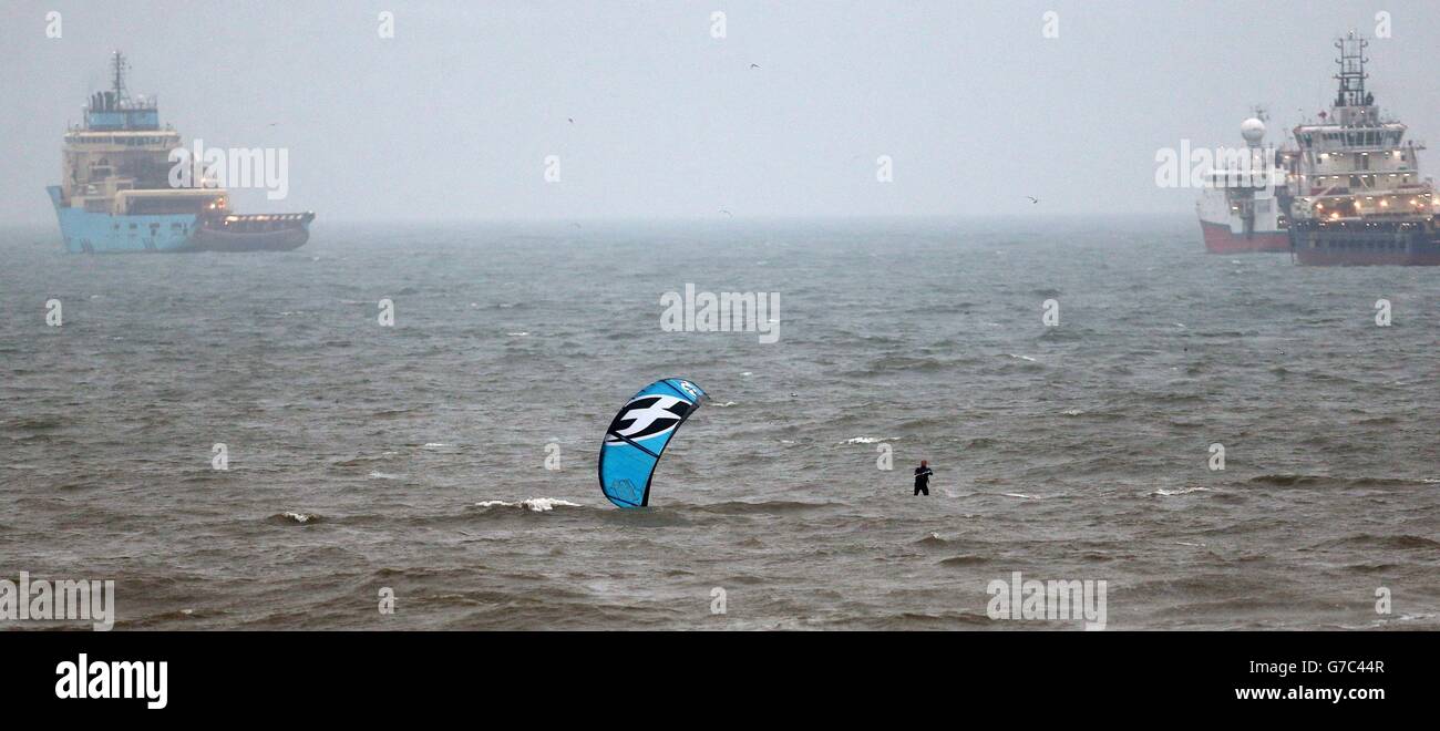 A kite surfer performing in front ships hi-res stock photography and ...