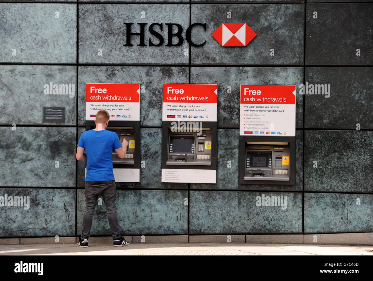 Cash machine stock. A member of the public withdraws money from an HSBC ...