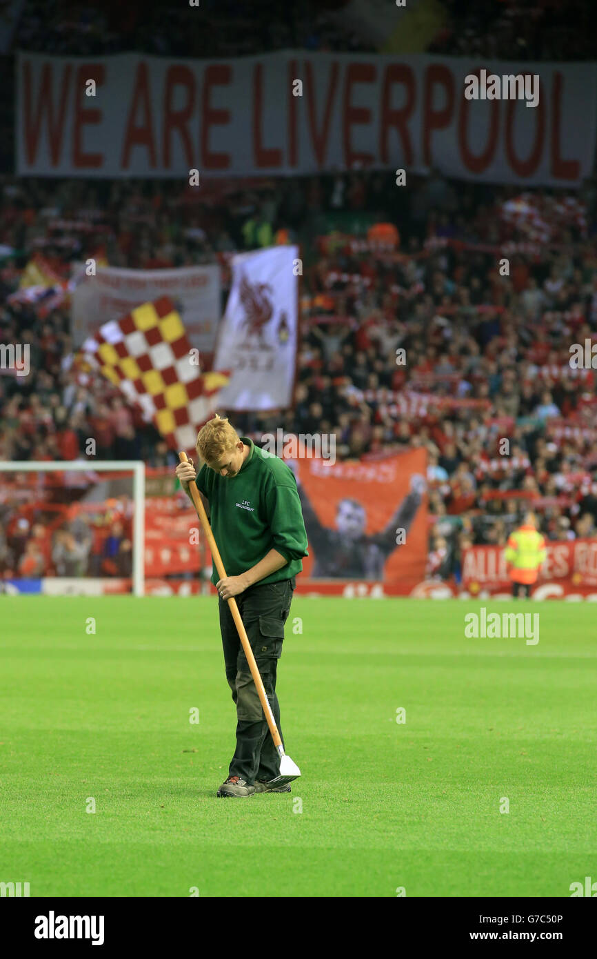 Liverpool fans in the Kop End as groundsmen go to work on the pitch ...