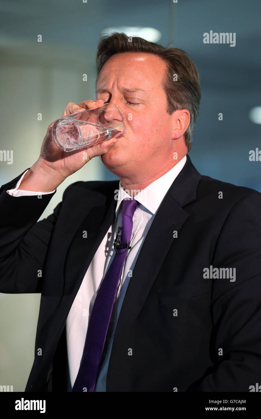 Prime Minister David Cameron has a drink of water during a visit to ...