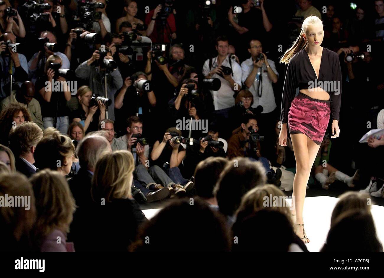 A model poses on the catwalk for photographers during the London ...