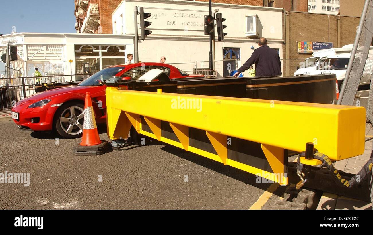 A car makes its way through huge concrete and steel barricades erected ...