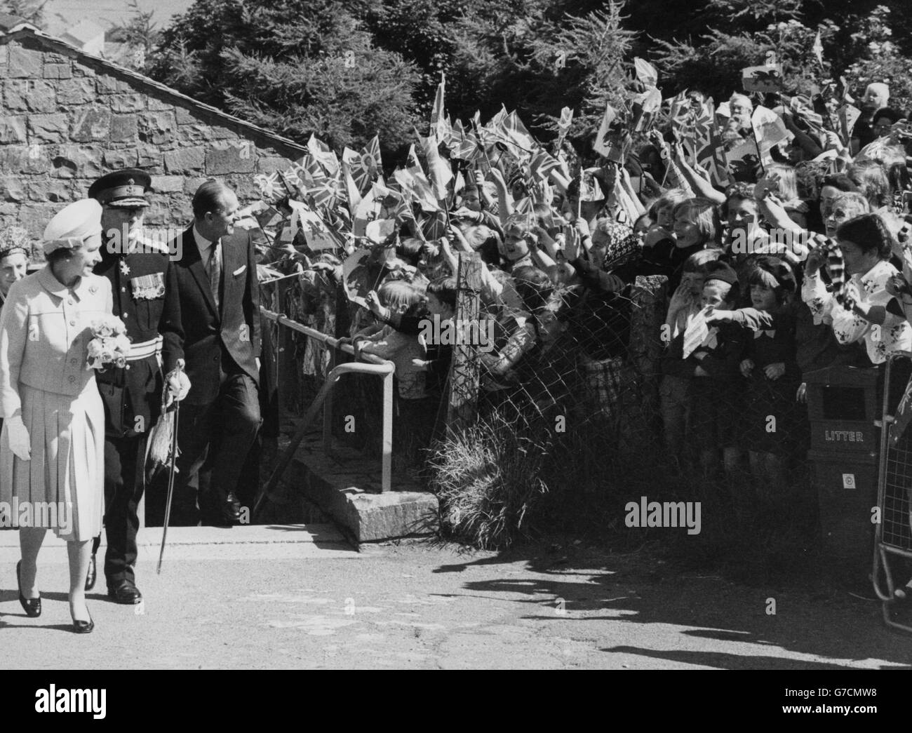 Queen Elizabeth II and the Duke of Edinburgh emerge to a cheering crowd ...