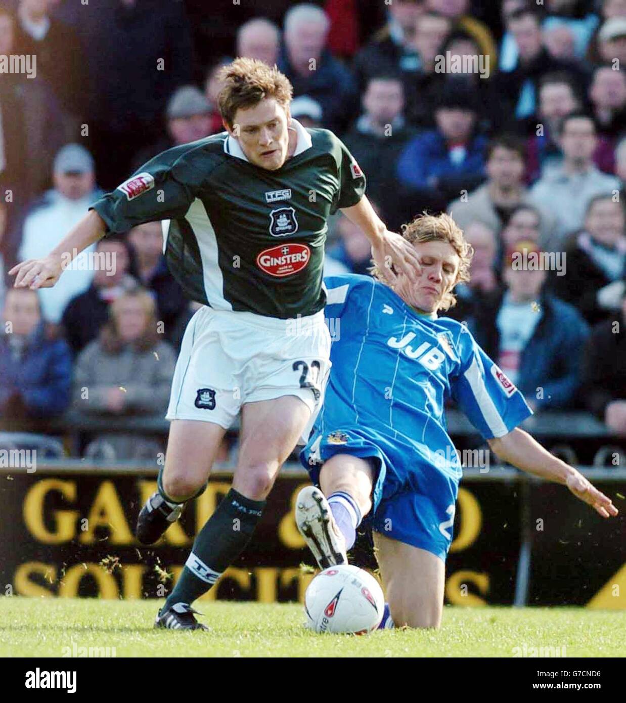Plymouth Argyle's Steve Adams (left) gets past Wigan's Jimmy Bullard ...