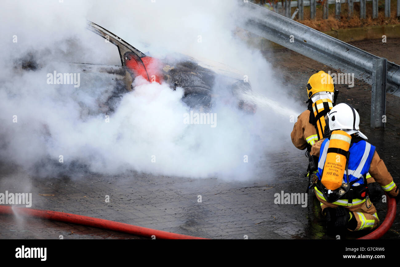 Firefighters attend to a car on fire during a Joint Emergency Services ...