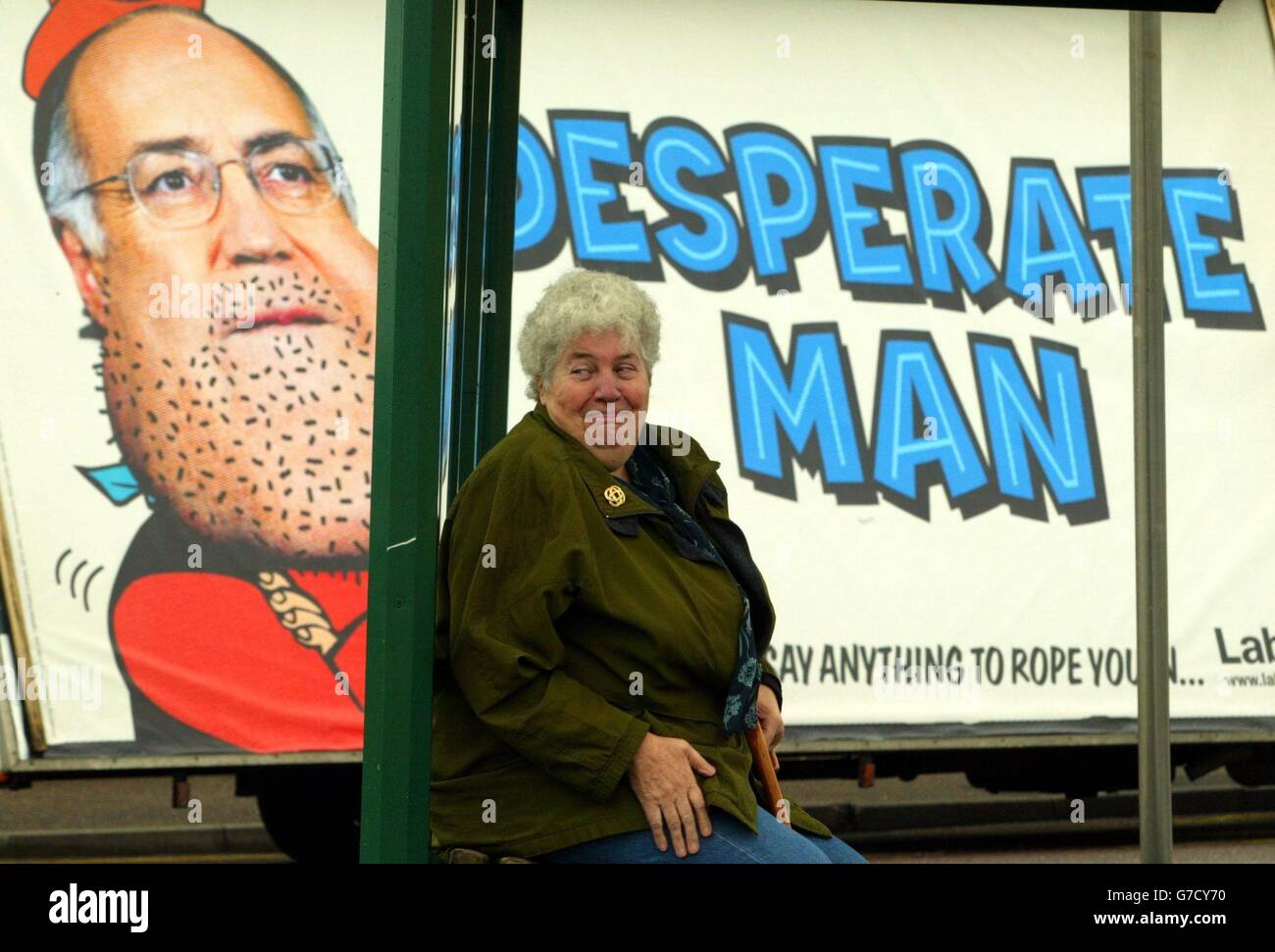 A lady laughs in front of a Labour Party poster outside the ...