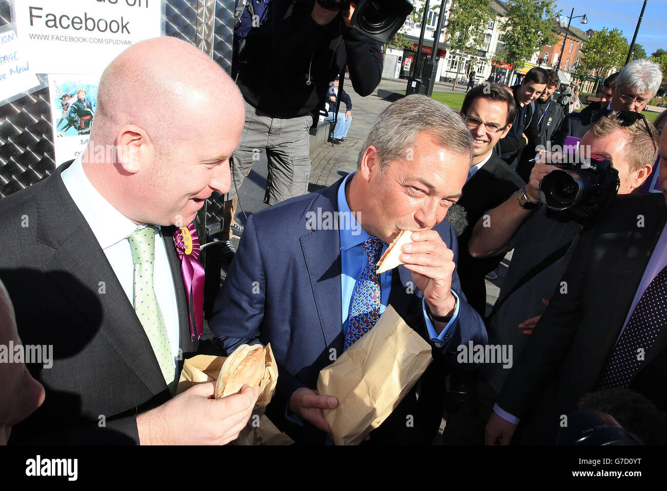 Leader of the Ukip party Nigel Farage (centre) eating a bacon sandwich ...