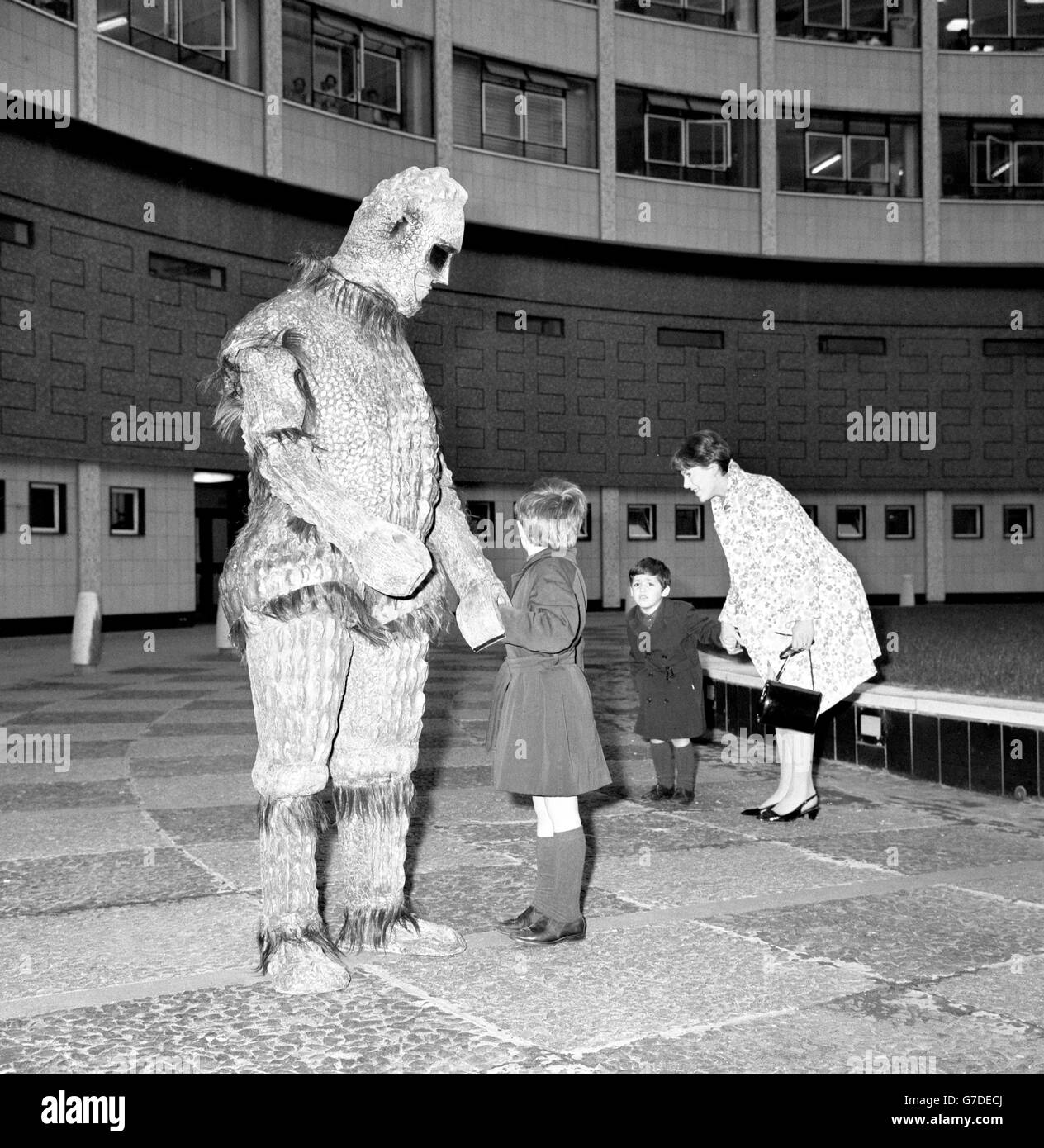 Actor Bernard Bresslaw, dressed as Varga from Dr Who, holds the hand of ...