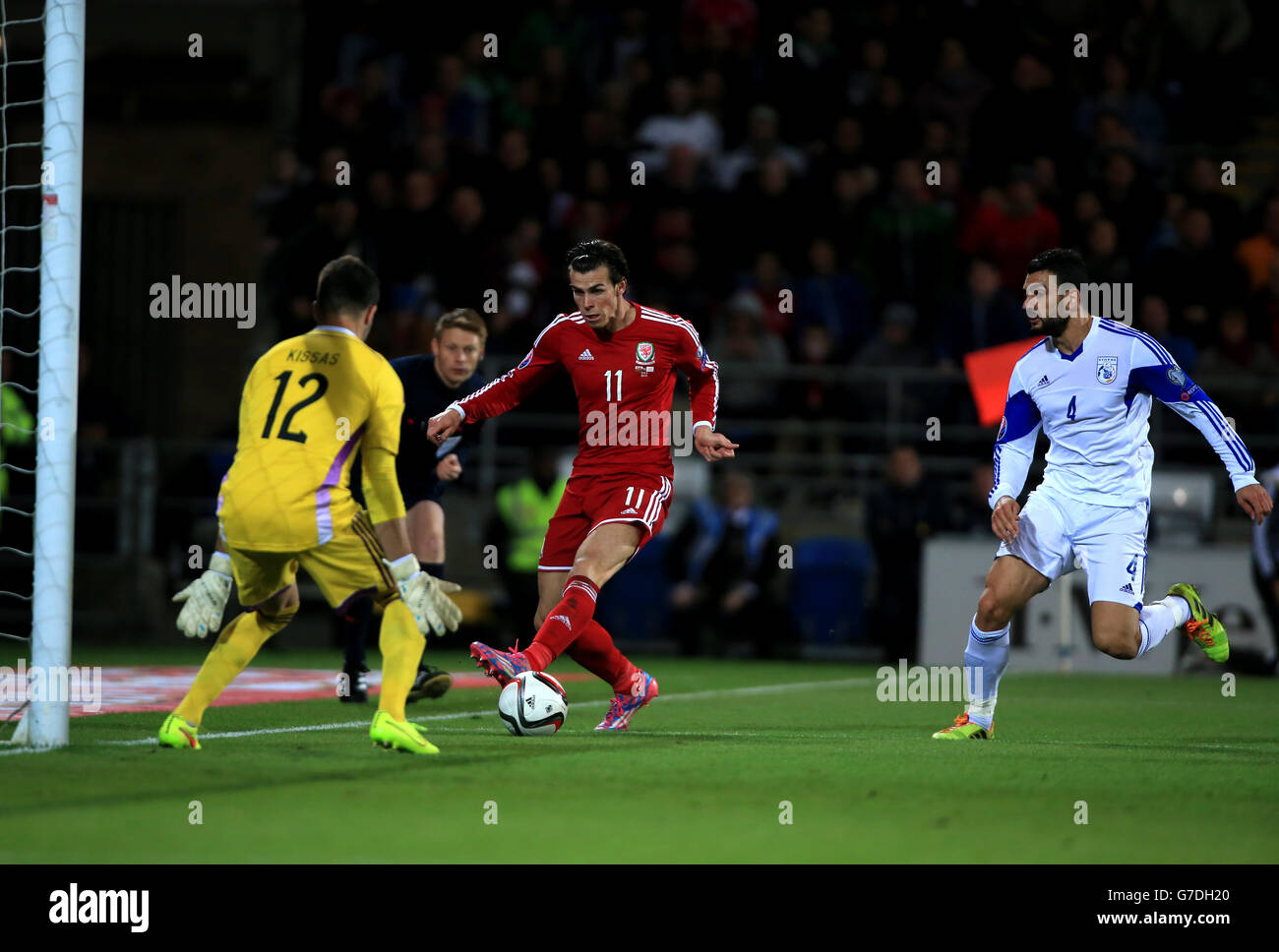 Wales' Gareth bale (centre) challenegs Cyprus' goal keeper Tasos Kissas ...