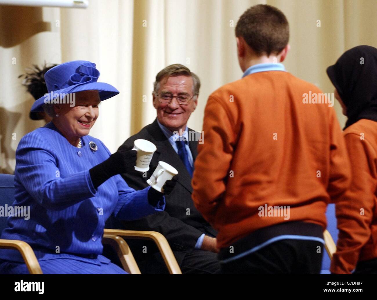 Britain's Queen Elizabeth II recieves two mugs from pupils during her ...