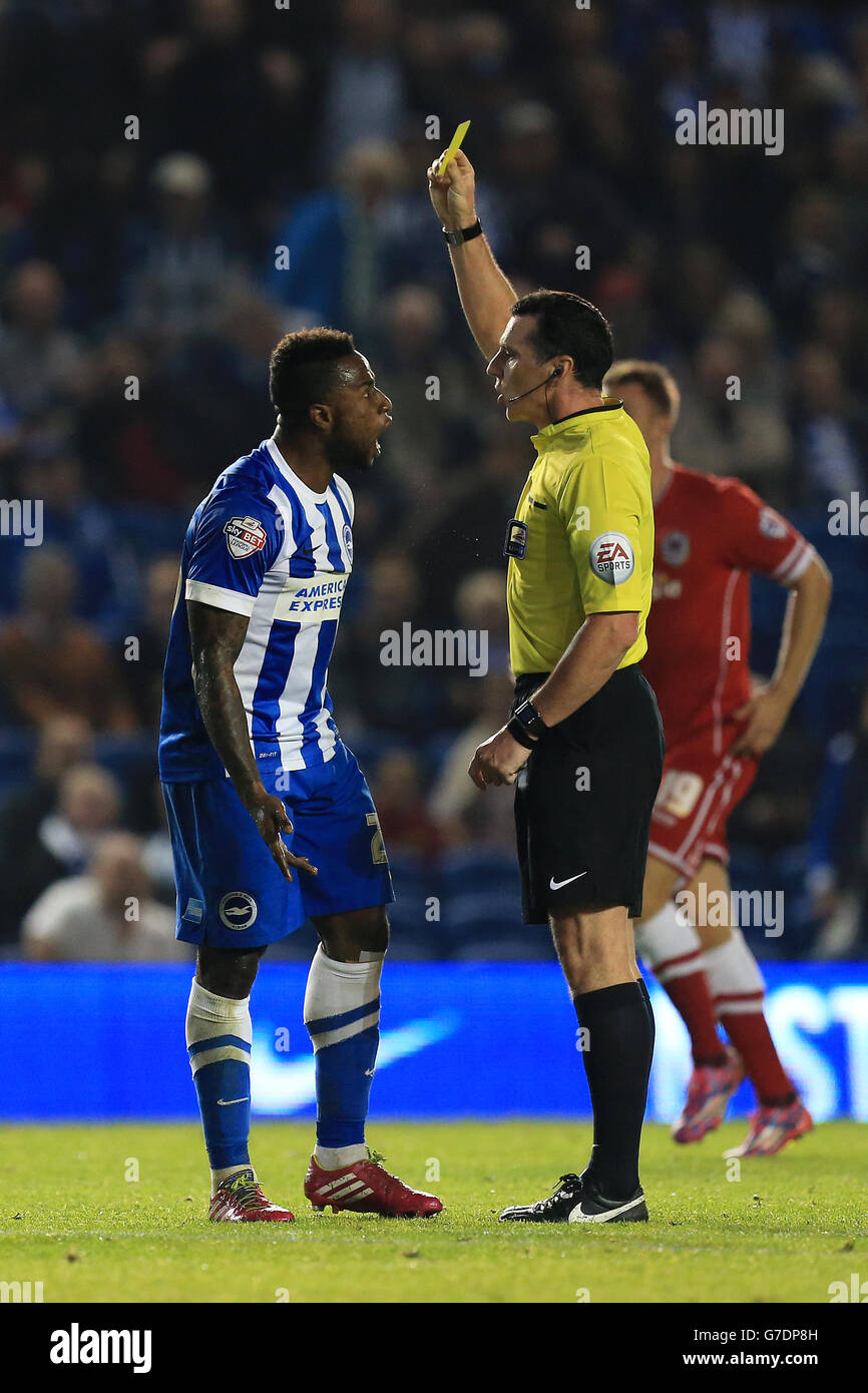 Brighton's Kazenga LuaLua is booked by referee Neil Swarbrick during ...
