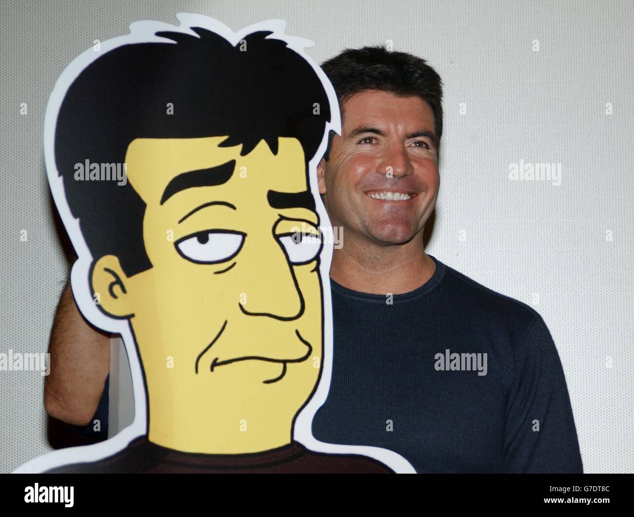 Simon Cowell poses with a cardboard cut-out of himself, as he arrives ...