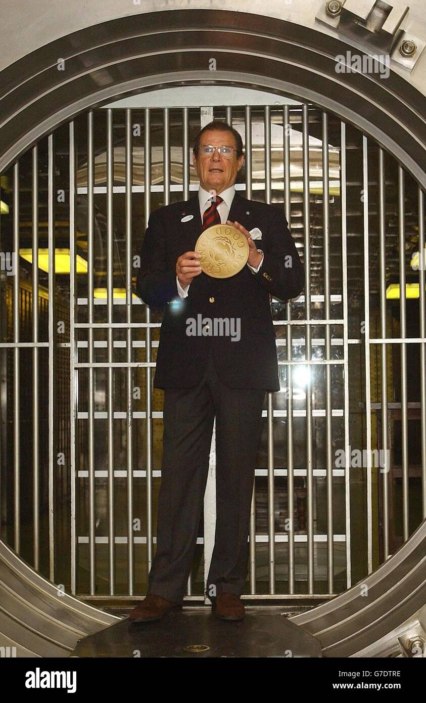 Sir Roger Moore poses for photographers by the Chatwood safe during a ...