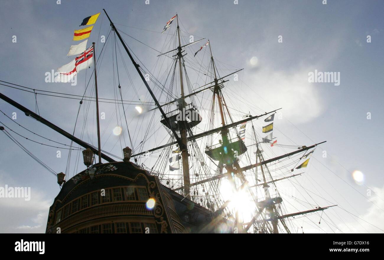 Flags are hoisted over HMS Victory at Portsmouth Naval Base during a ...